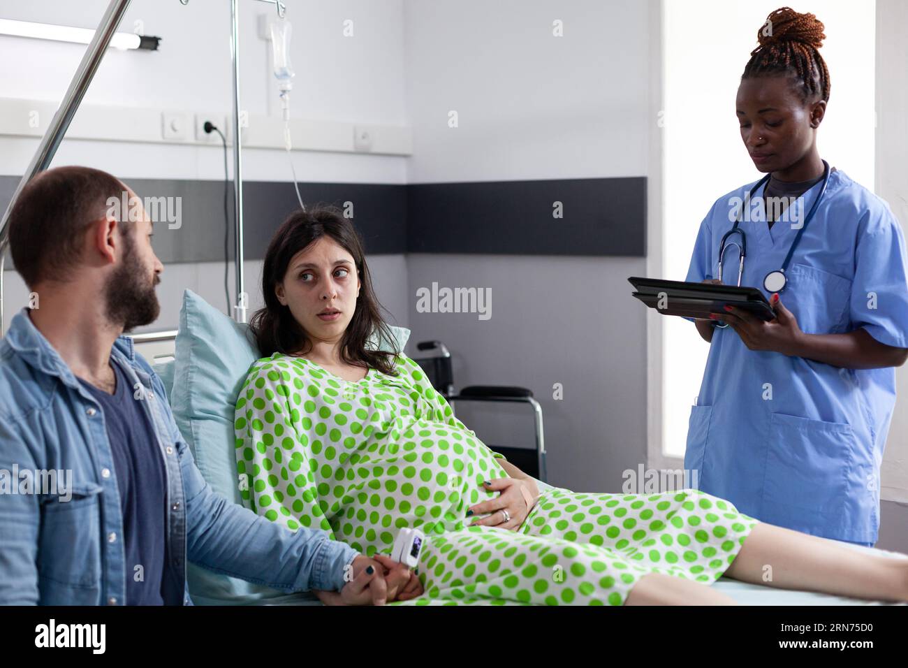 Couple receiving medical assistance from african american nurse before ...