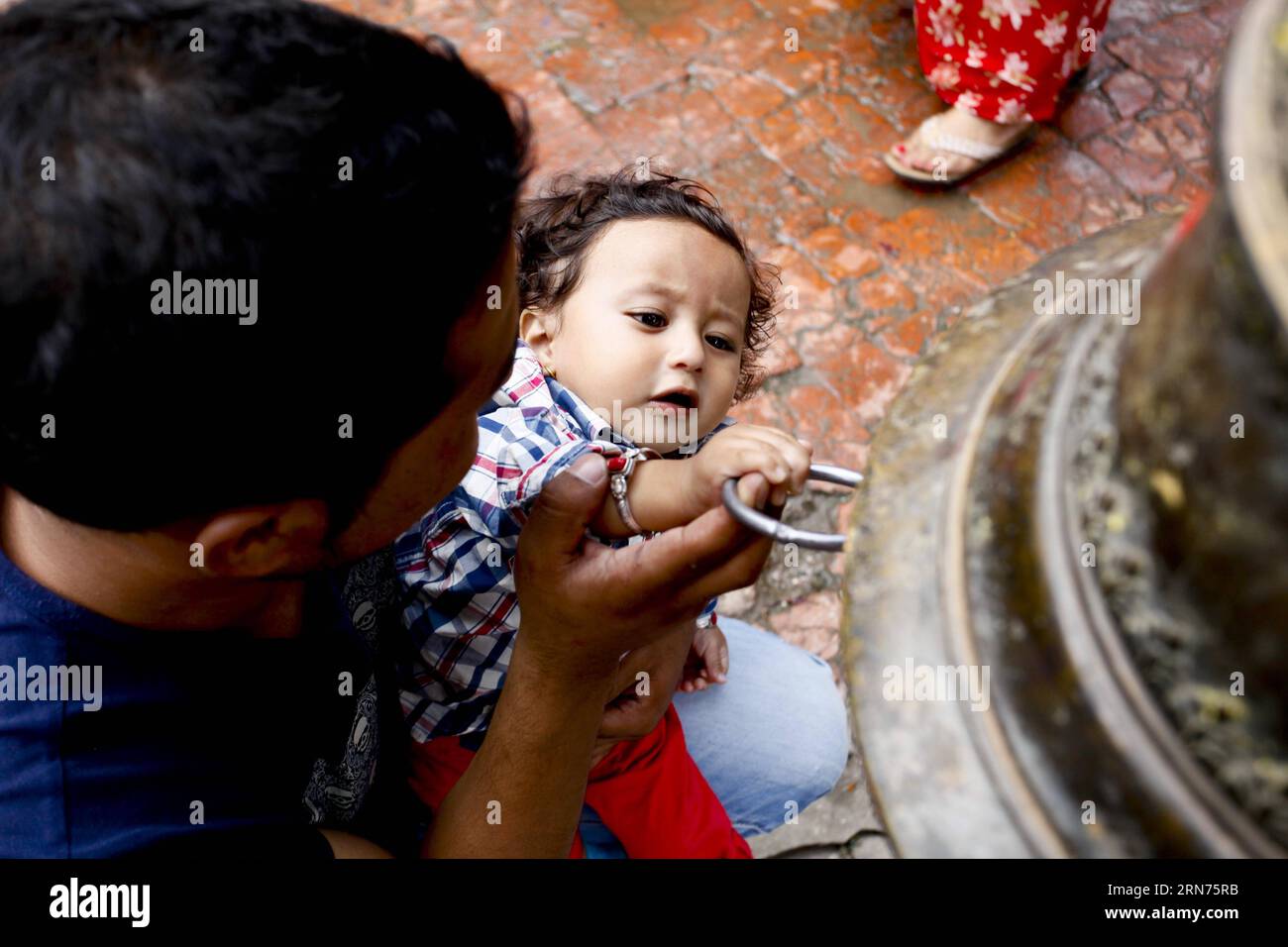 KATHMANDU, Aug. 18, 2015 -- A child rings a bell during the Bagh ...