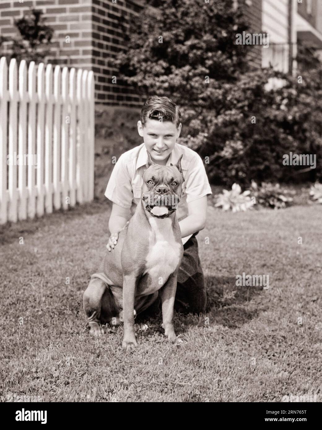 1940s 1950s PRE-TEEN BOY IN BACKYARD POSING WITH HIS PET BOXER DOG BOTH ...