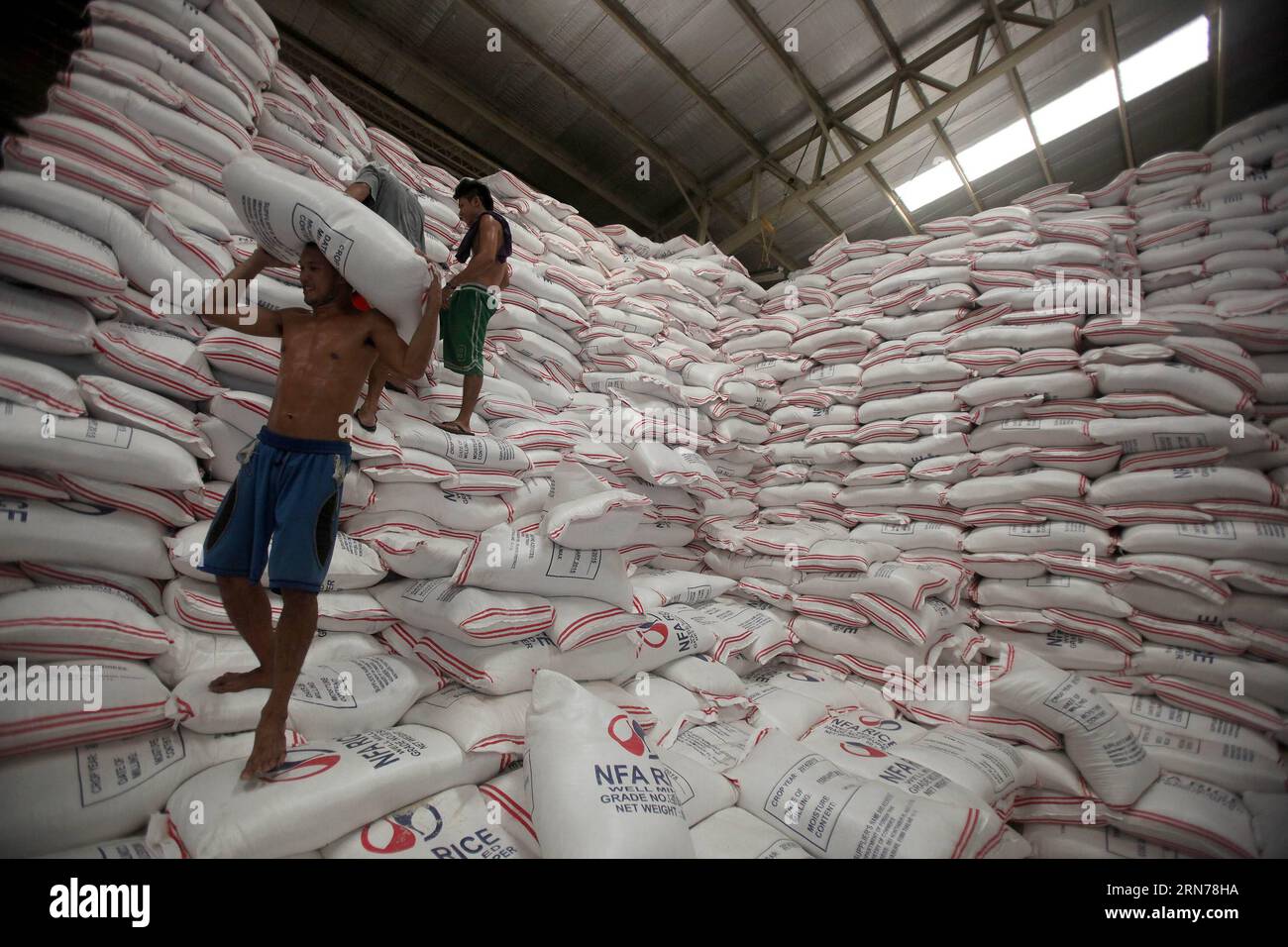 (150825) -- QUEZON CITY, Aug. 25, 2015 -- Workers carry sacks of rice ...