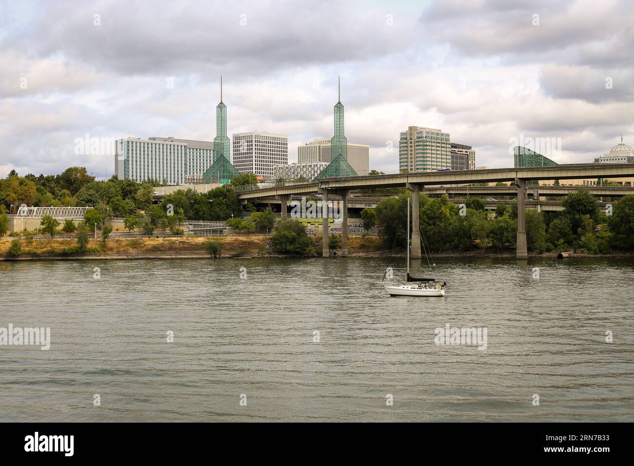 Sailboat in the Willamette River with a bridge, cityscape, and the ...