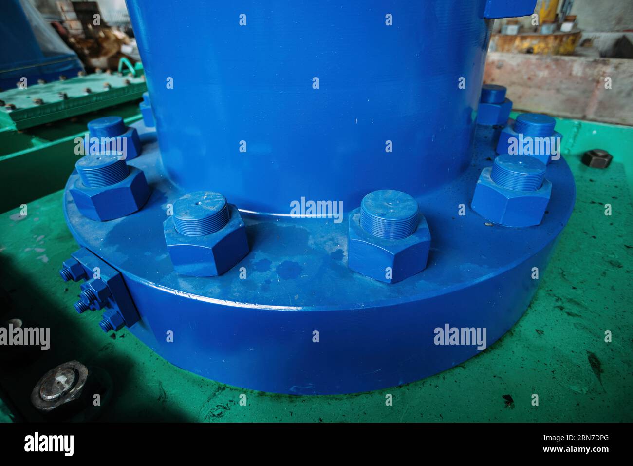 Bolts and nuts on blue flange of joint of hydraulic jack on ...