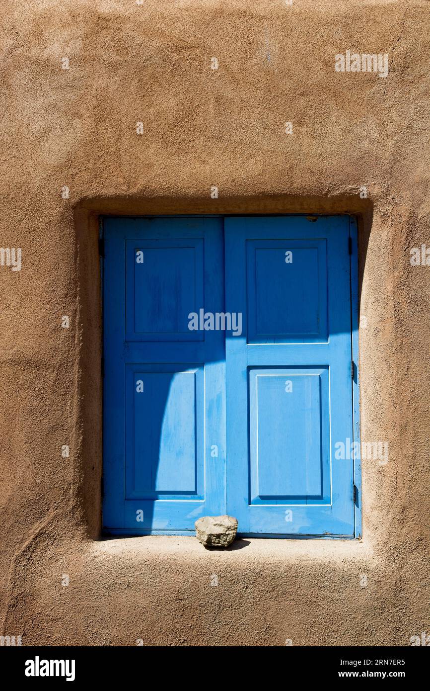 Bright blue shutters cover window of adobe structure at historic ...