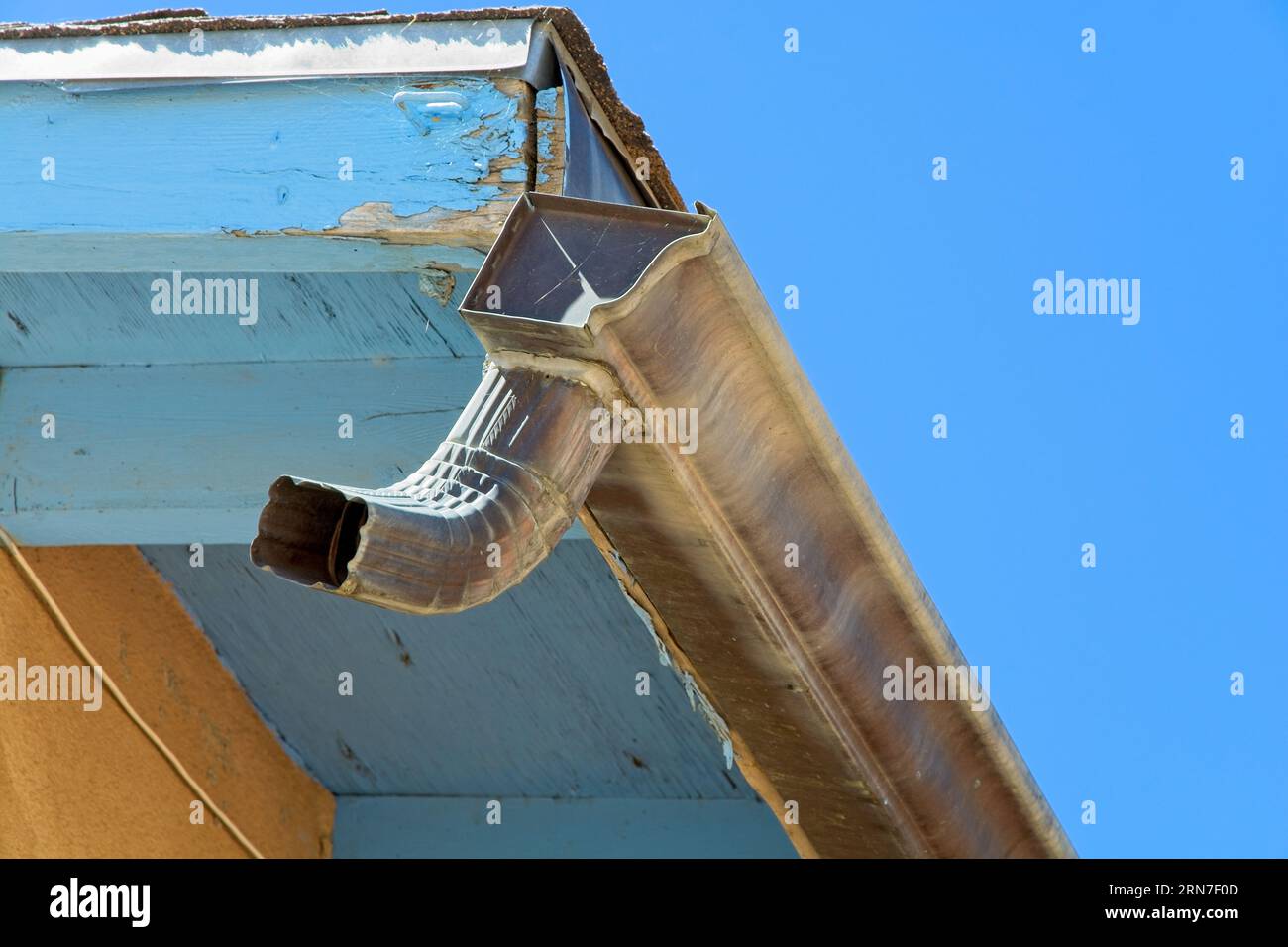 Weathered aluminum gutter hanging from roof fascia Stock Photo - Alamy