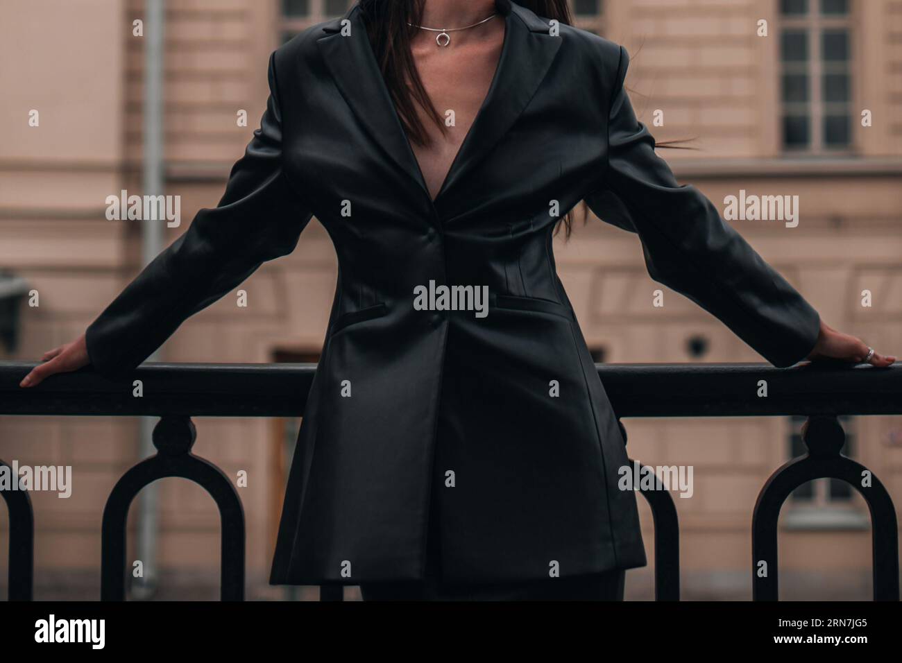 Fashionable details of a black leather skirt, jacket and handbag. Woman ...