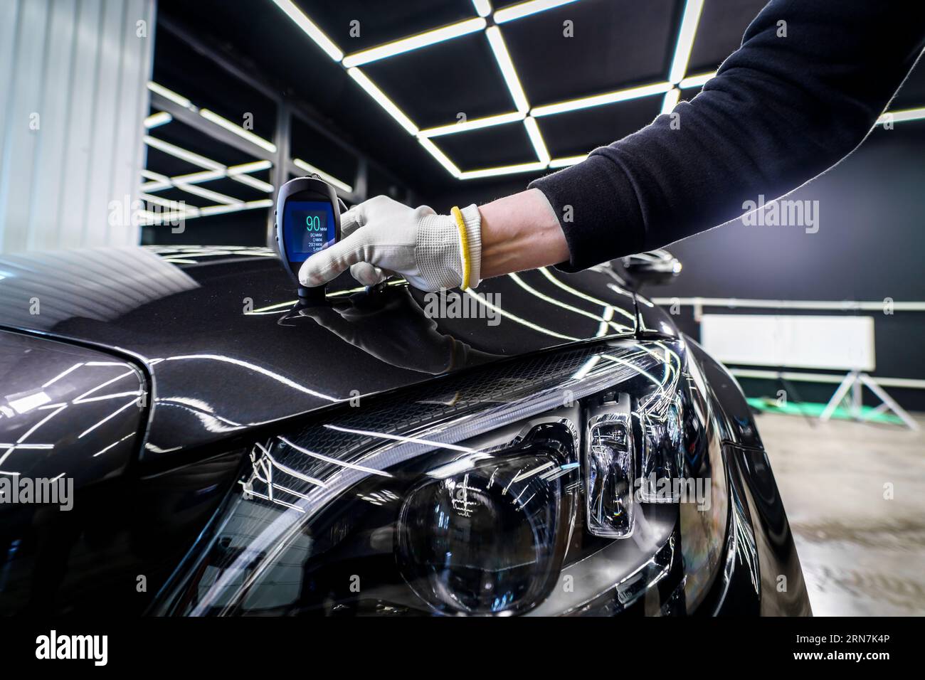Measuring the thickness of a car paint coating with a thickness gauge ...