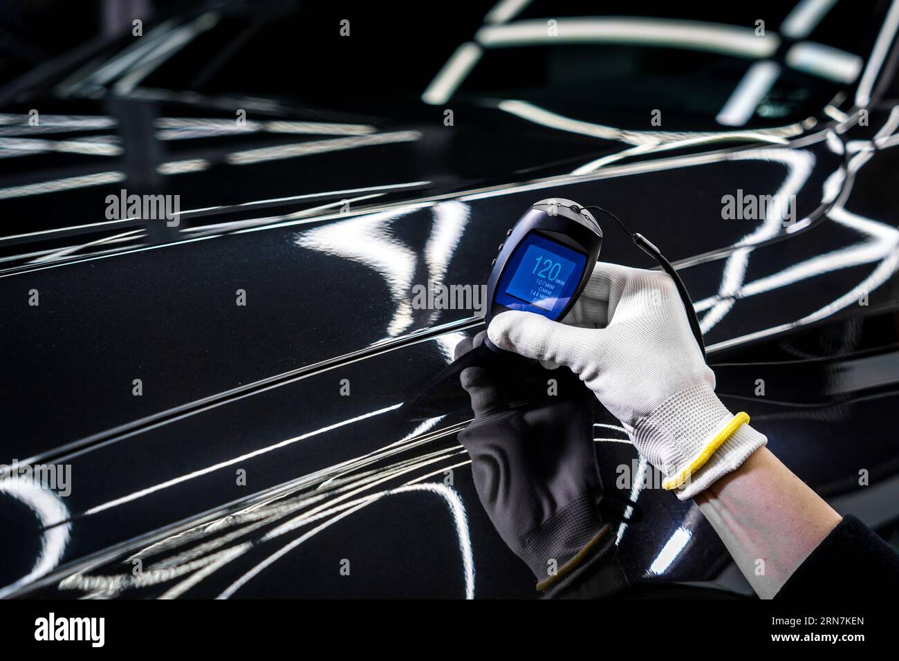 Measuring the thickness of a car paint coating with a thickness gauge ...
