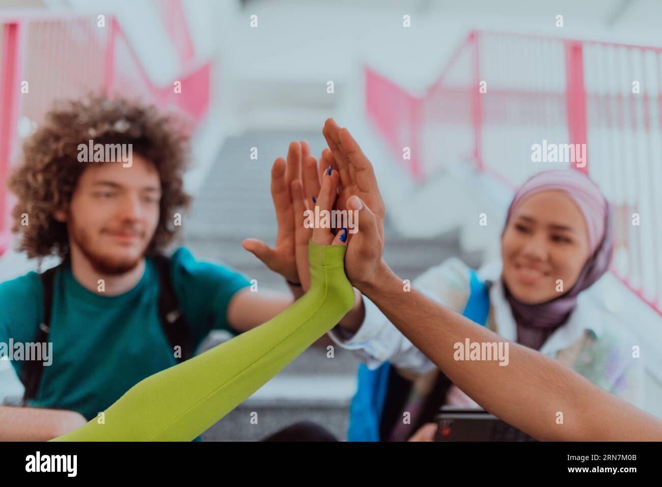 A diverse group of students symbolizes unity as they interlace their ...