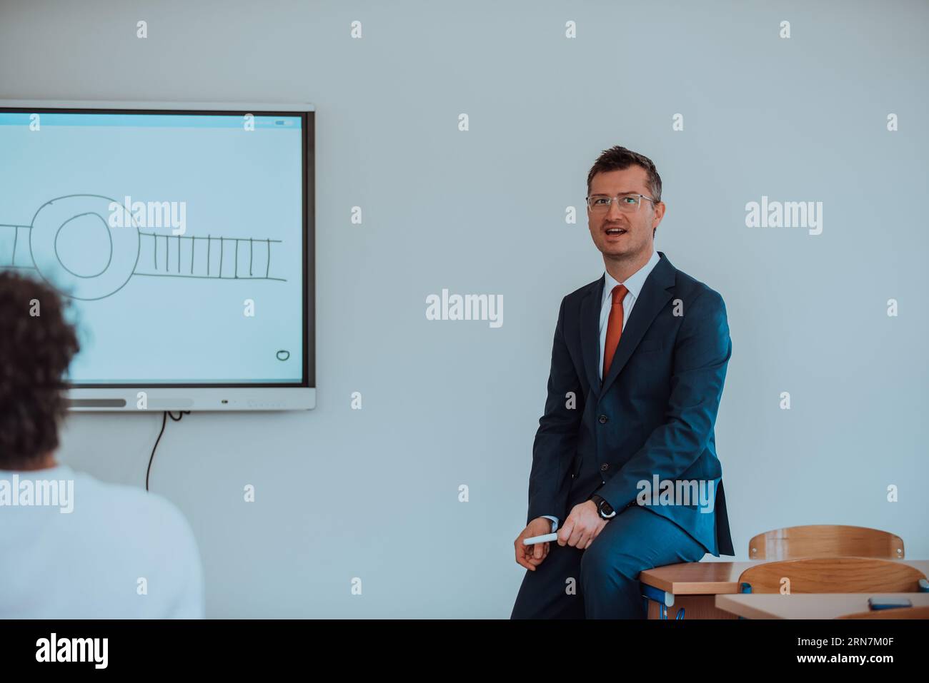 A modernly dressed professor engages in educating students, who listen ...