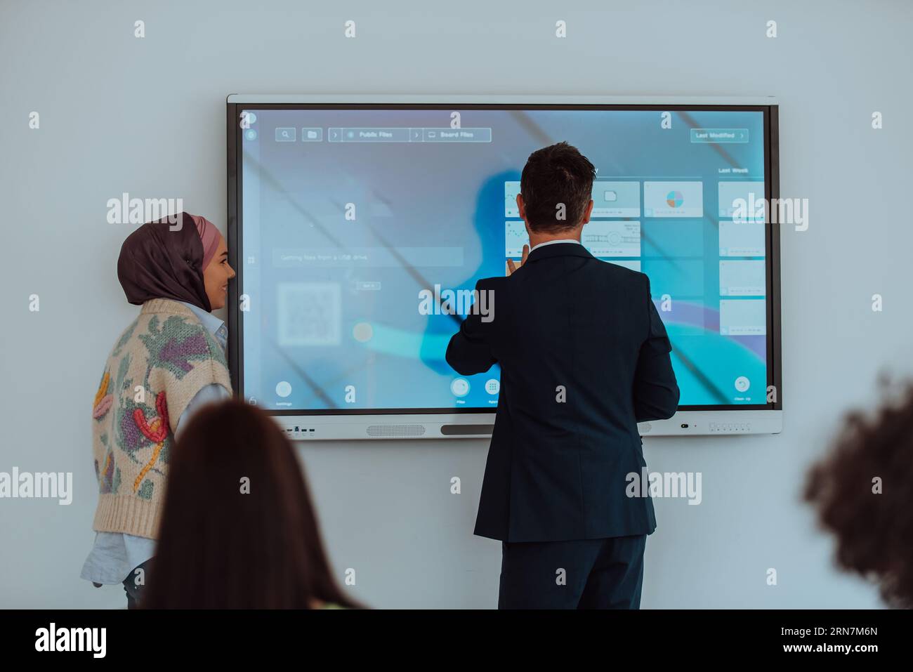 A modernly dressed professor engages in educating students, who listen ...