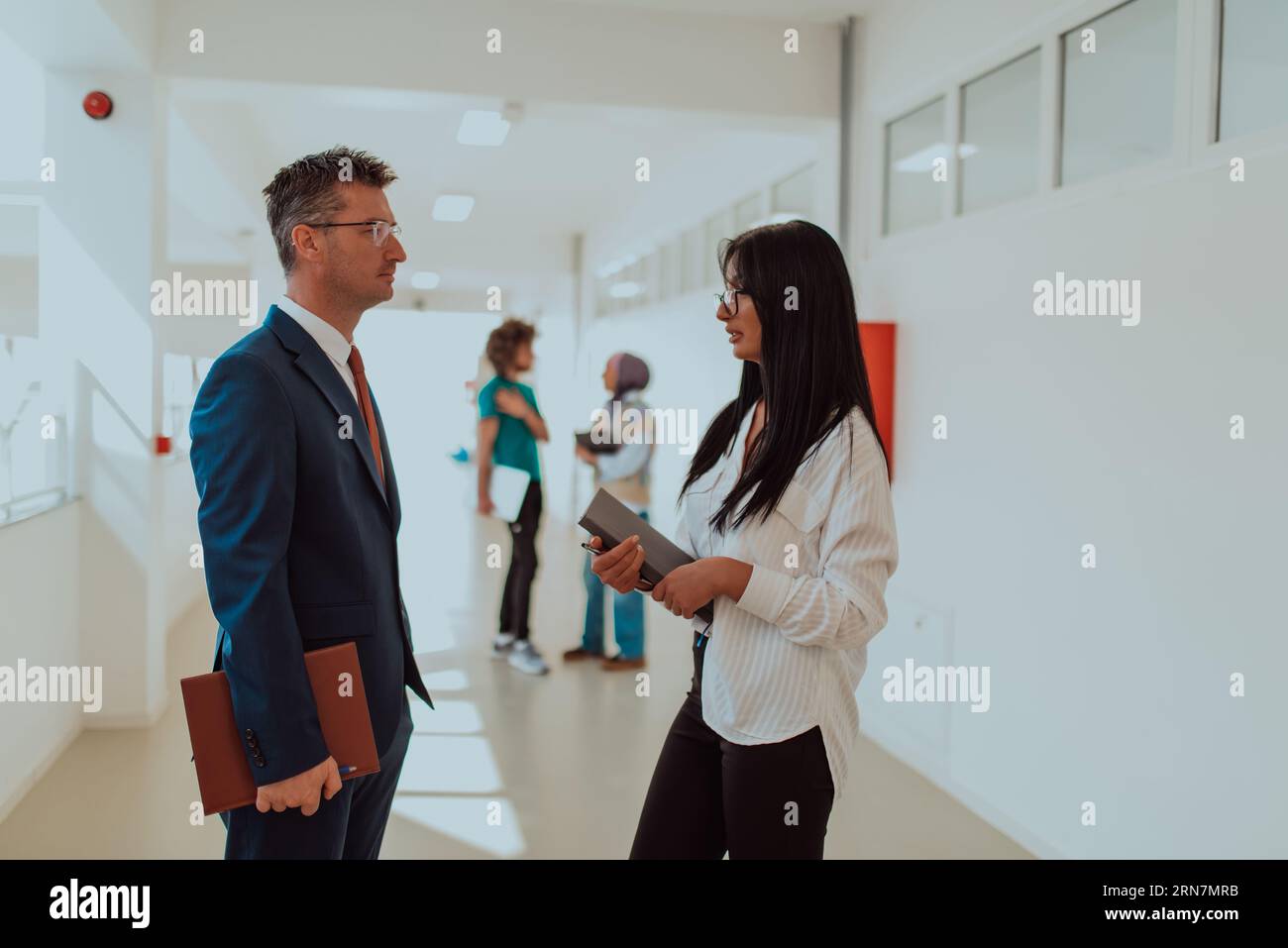 Business colleagues engage in a knowledge-sharing conversation during a ...