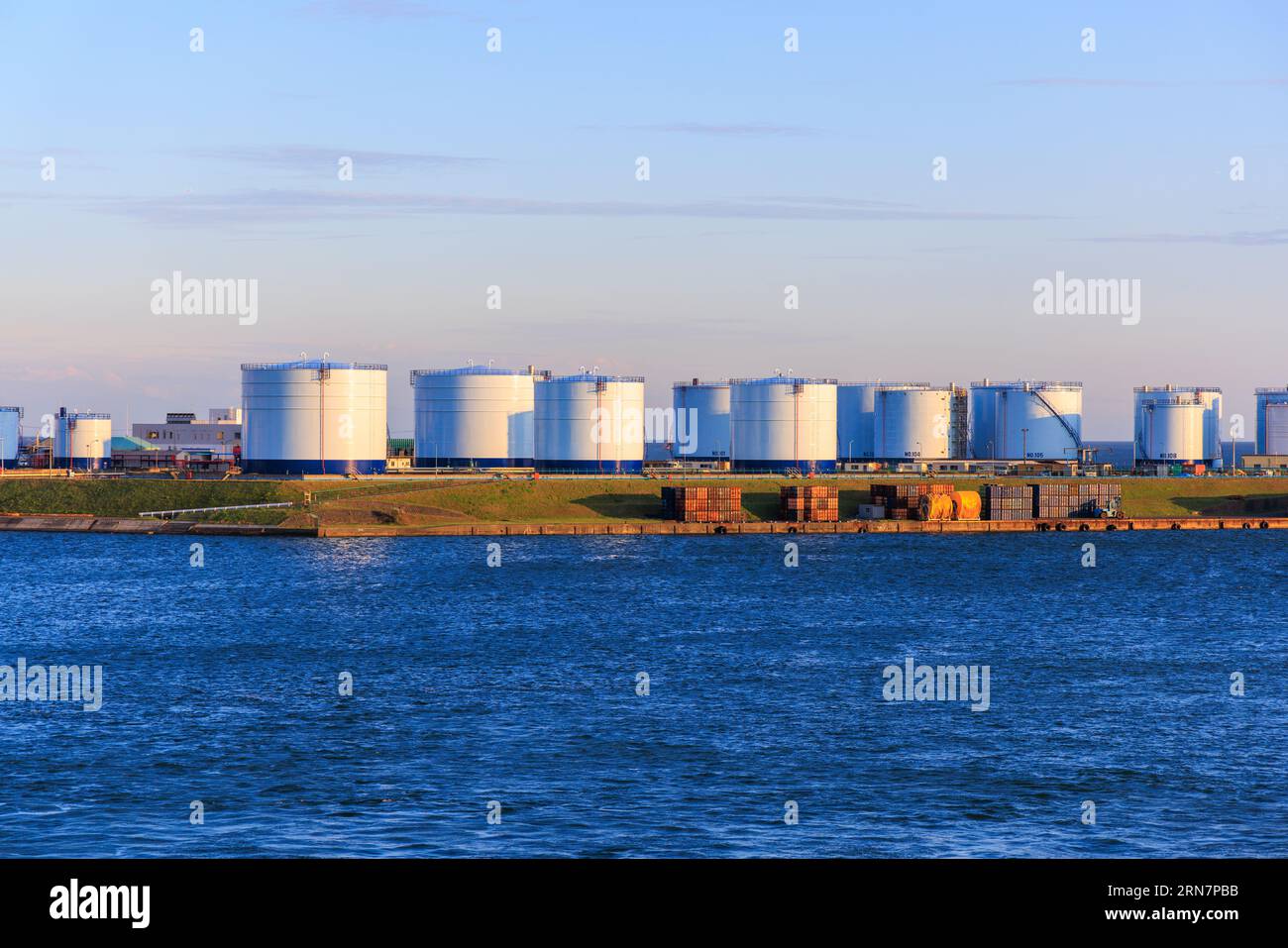 LNG storage tanks at coastal storage facility with blue ocean and sky ...