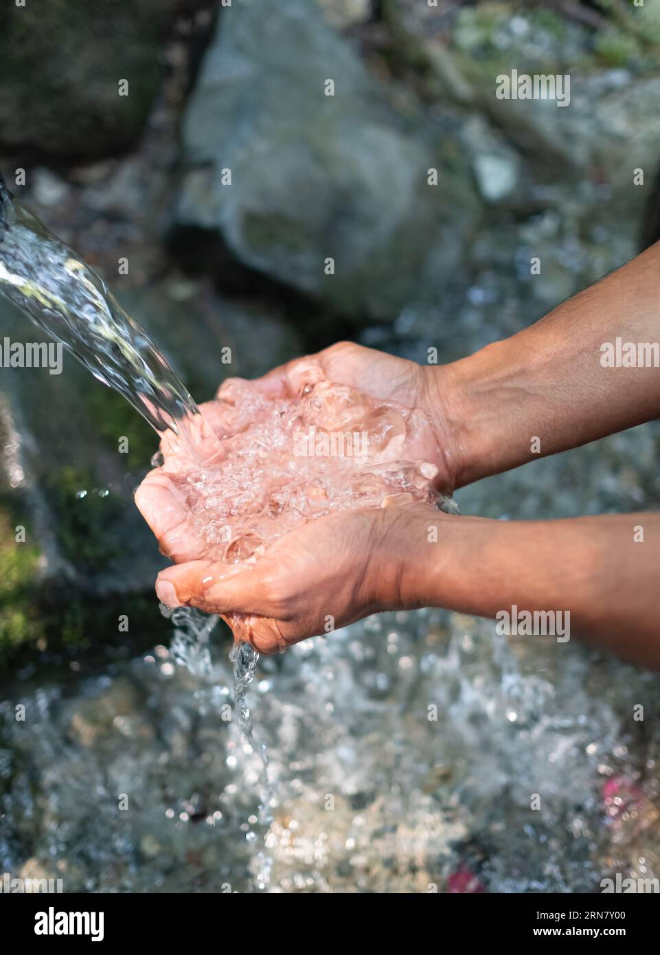Hands, water splash and washing in nature outdoor. Man scoops up water ...