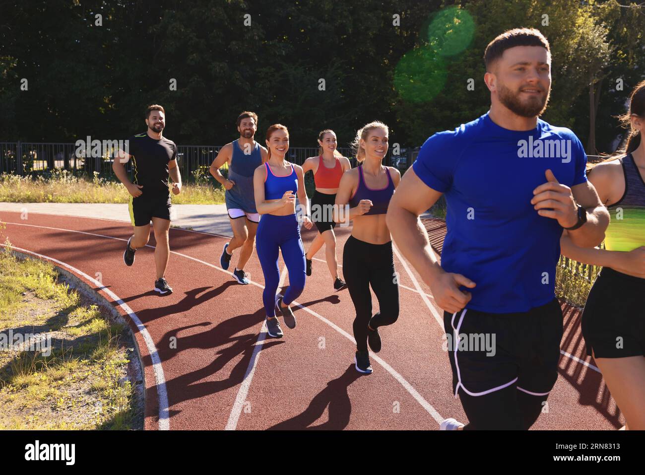 Group of people running at stadium on sunny day Stock Photo - Alamy