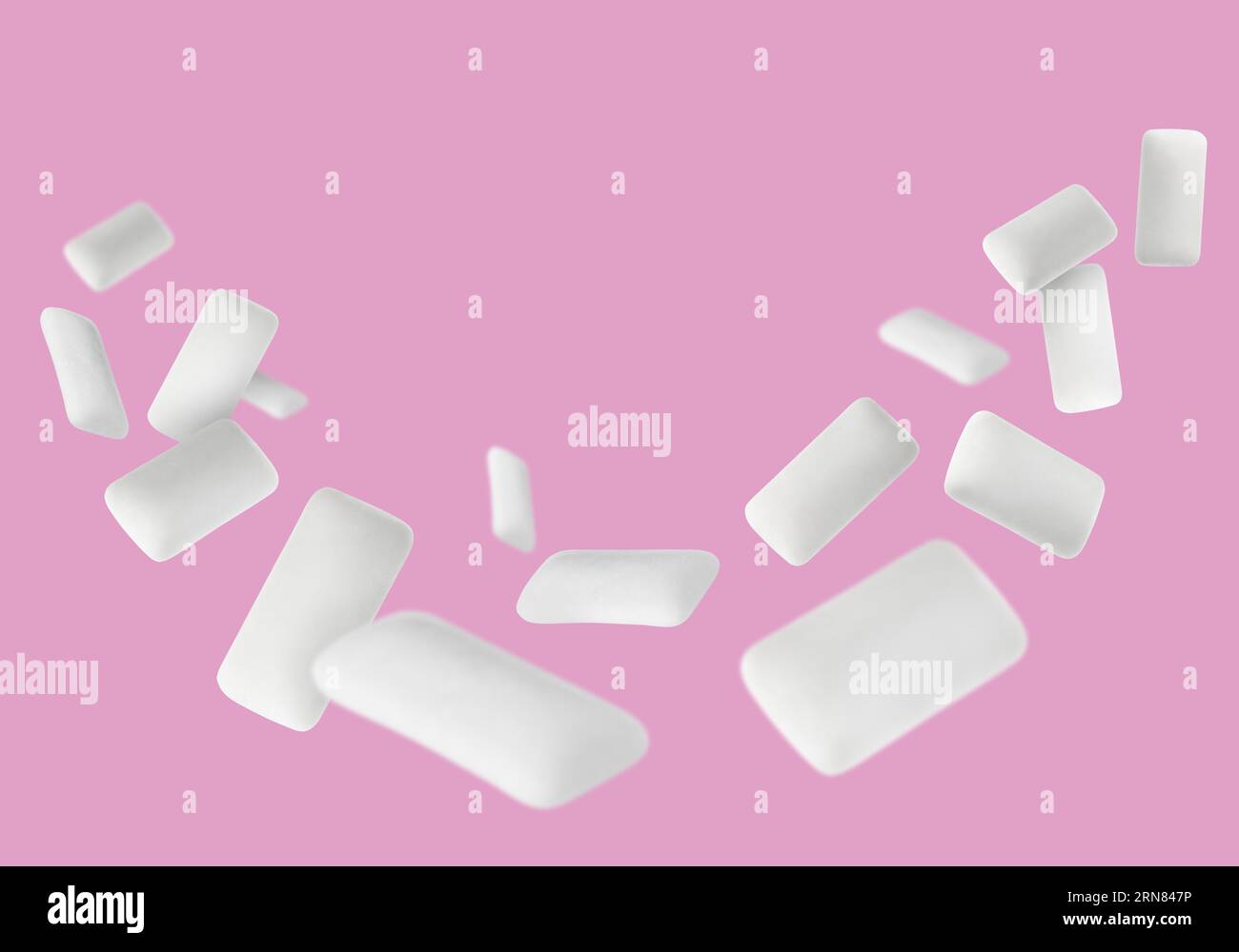 Many chewing gum pads falling on pink background Stock Photo - Alamy