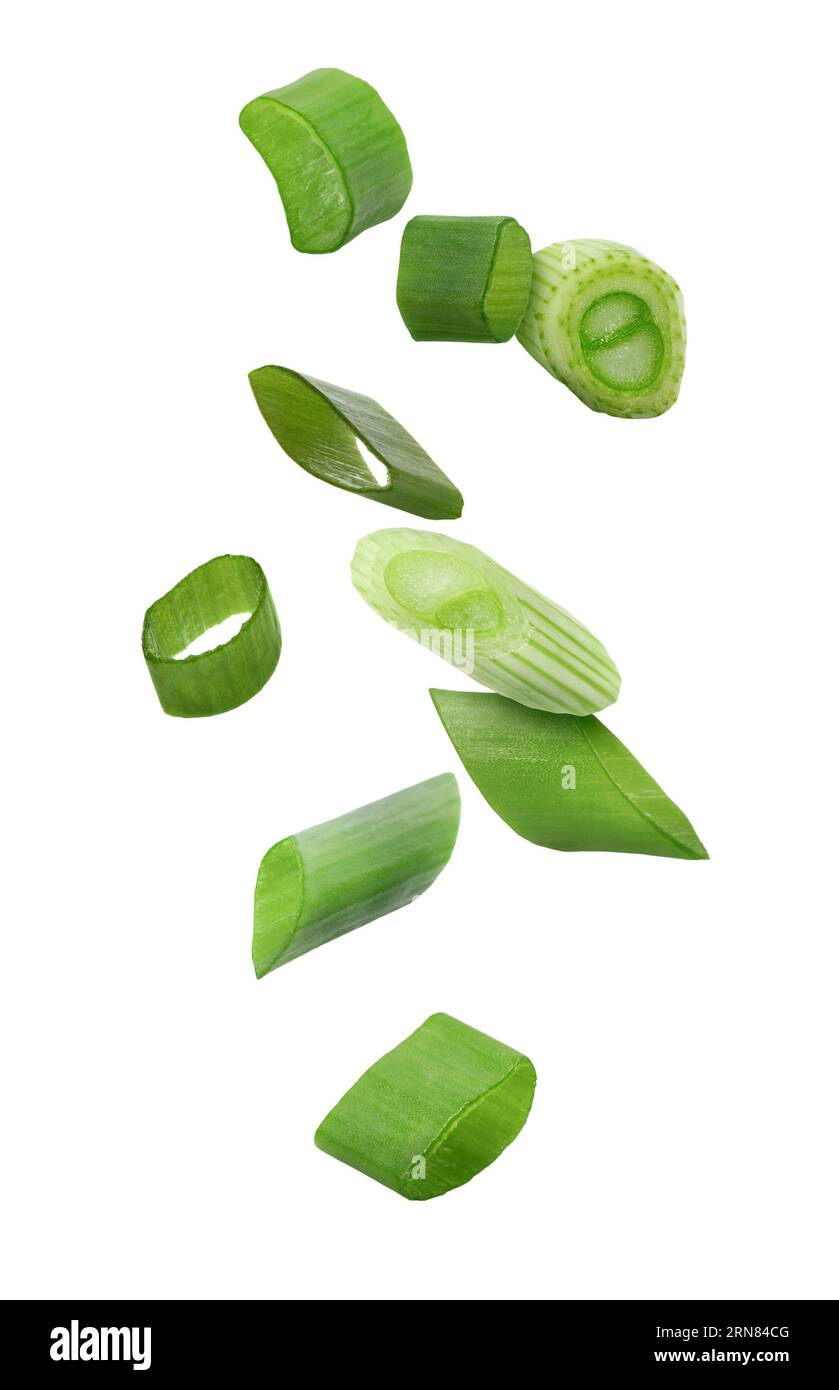 Cut green onion falling on white background Stock Photo - Alamy