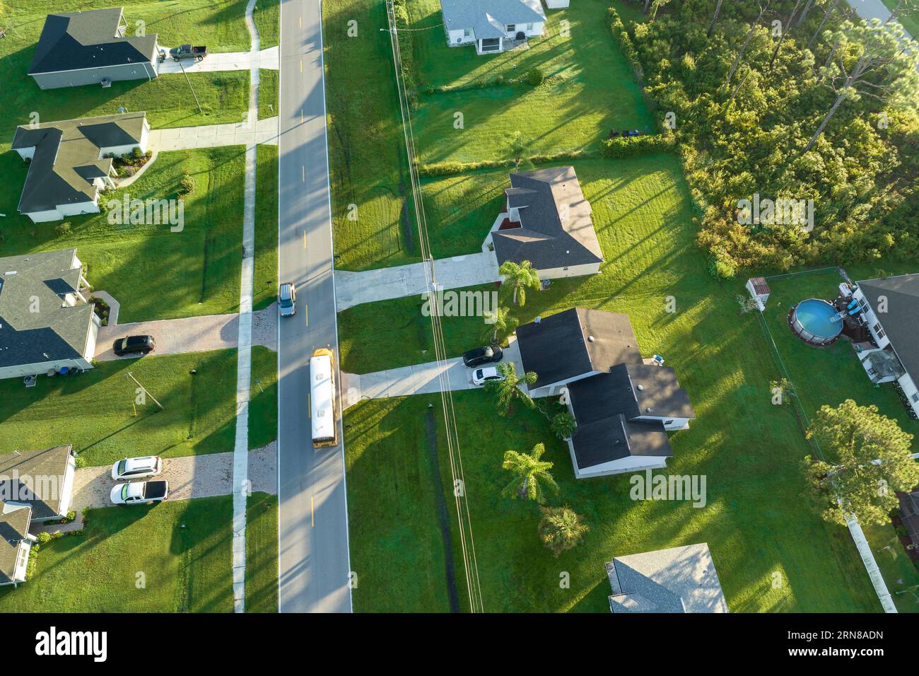 Aerial view of american yellow school bus driving on suburban street ...