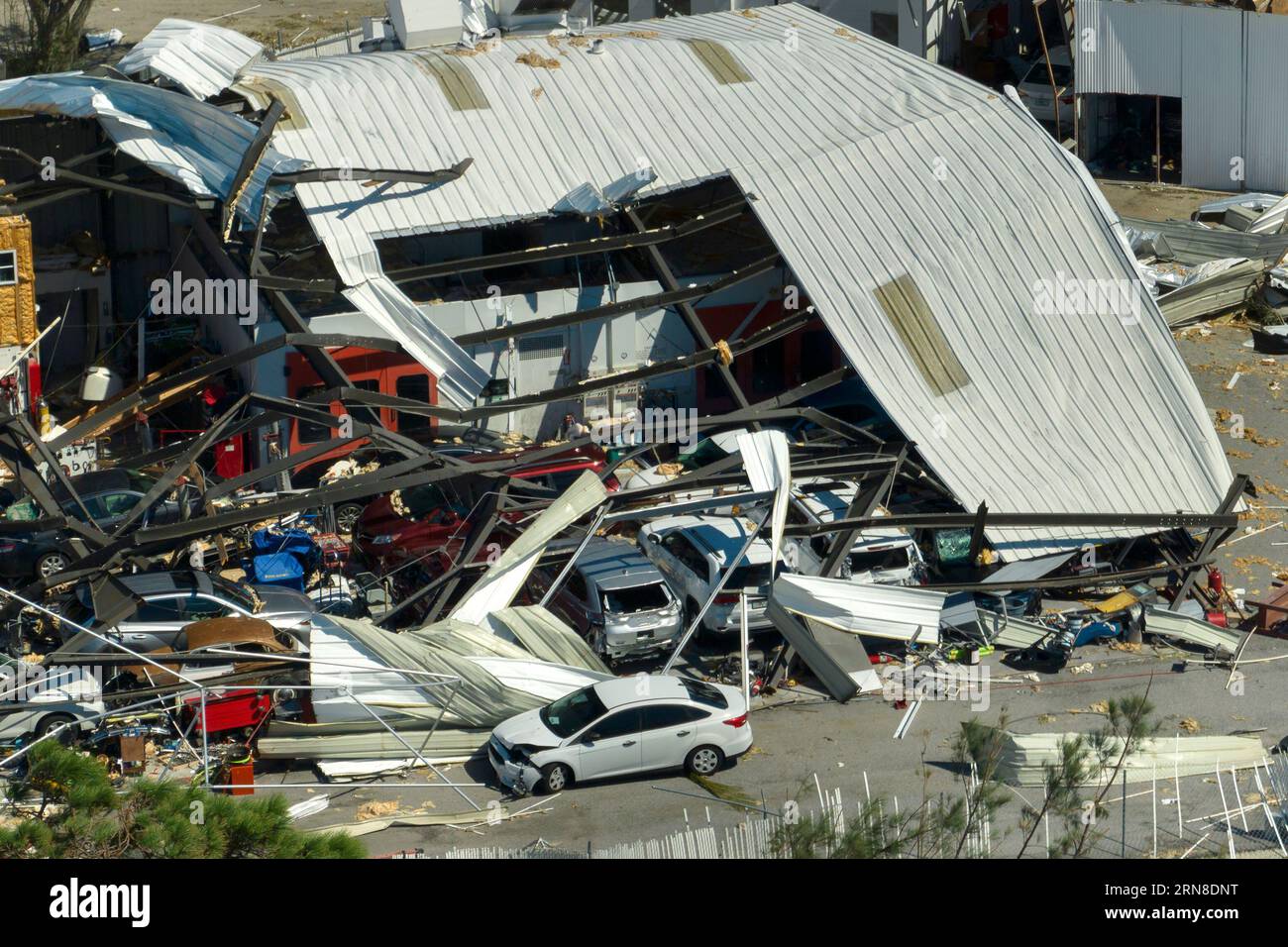 Automotive workshop destroyed by hurricane wind with damaged cars under ...