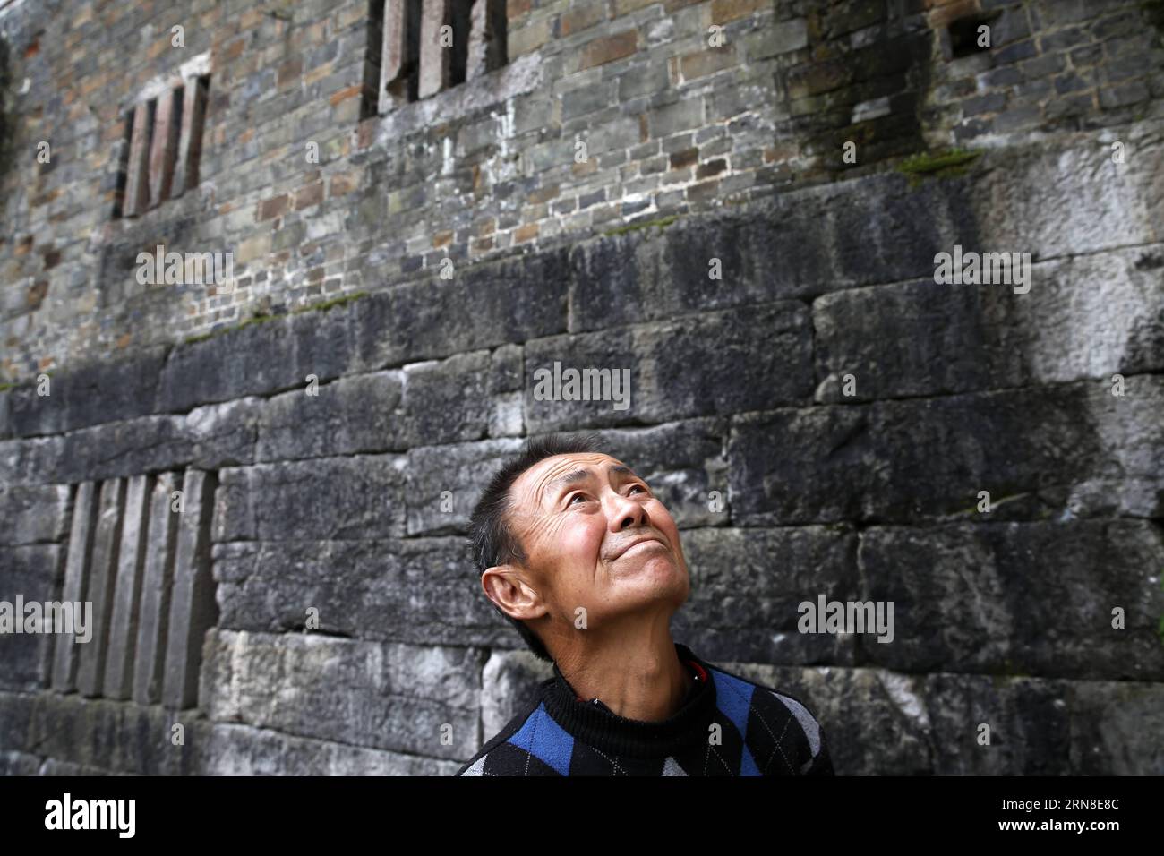 Senior citizen Li Qingyi looks at the old buildings in Apengjiang Town ...