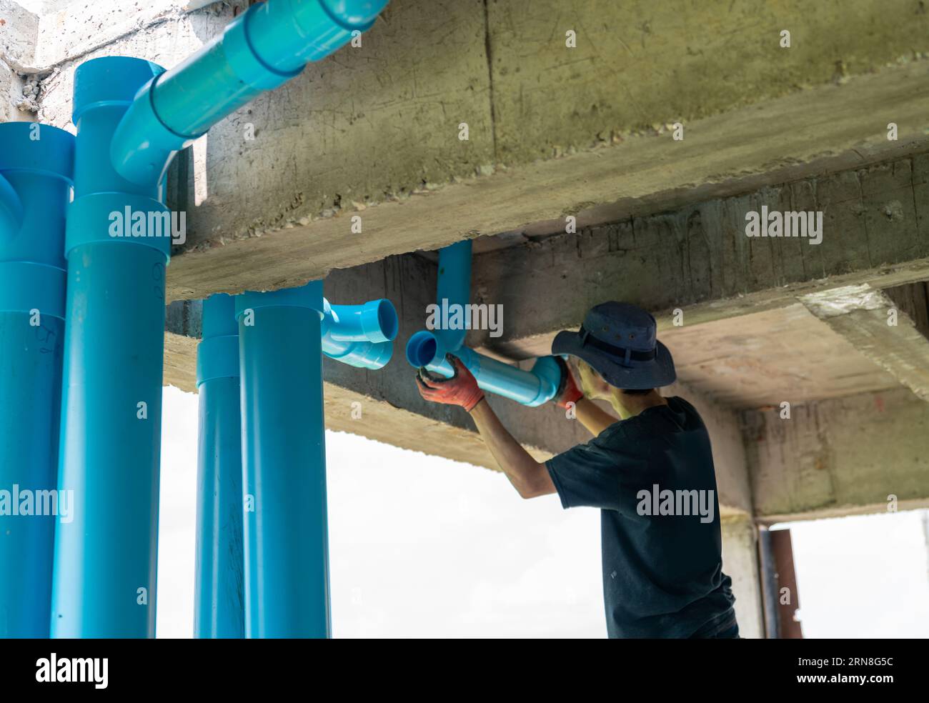 Plumber hands holding PVC pipe connect drain water in new building ...