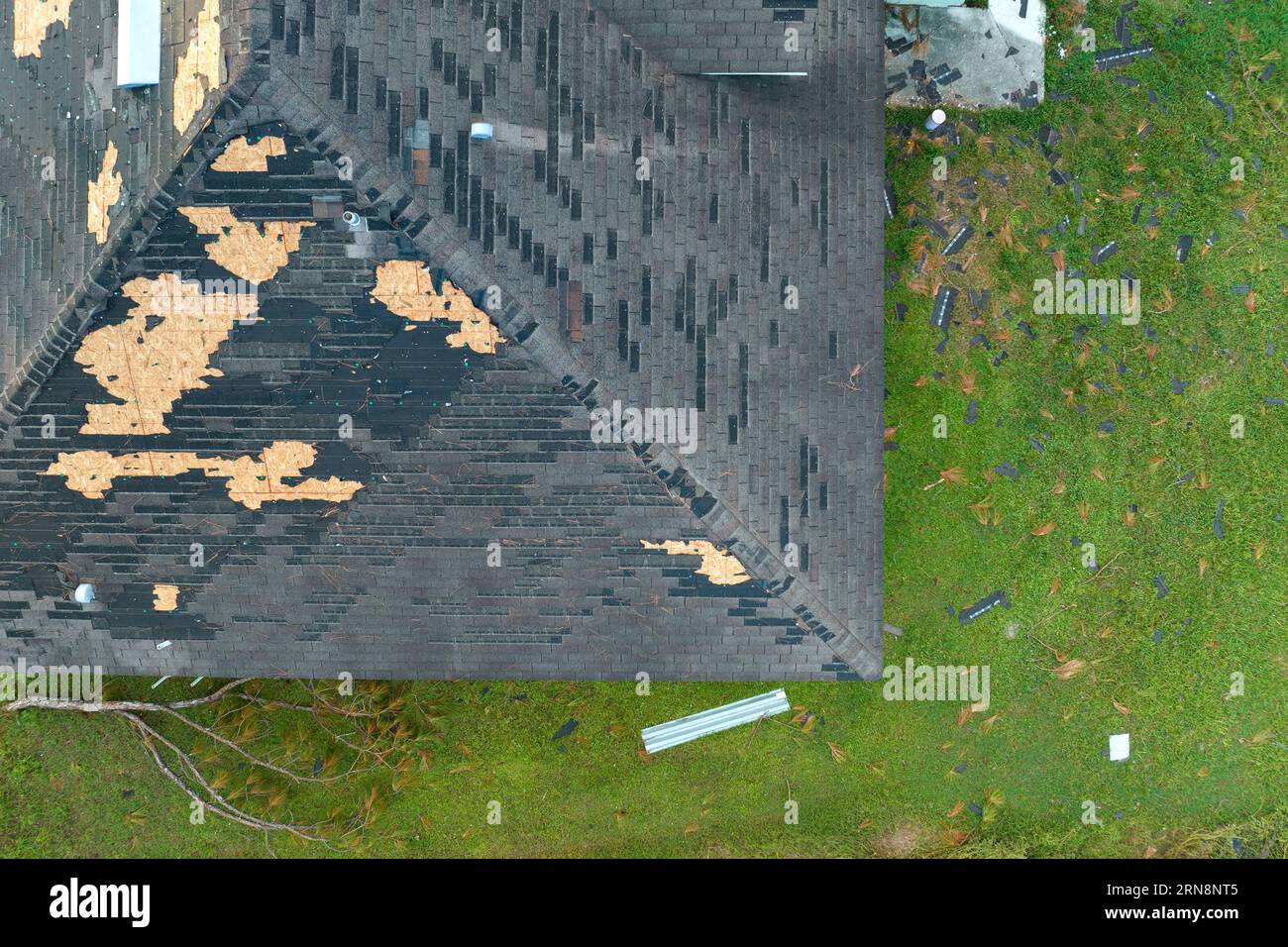 Ruined rooftop in need of repair. Wind damaged house roof with missing ...