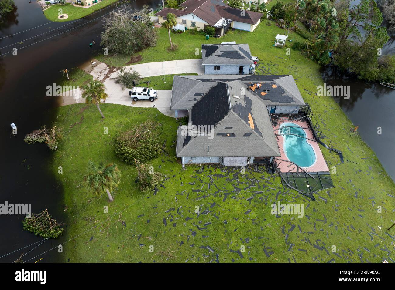 Hurricane Ian destroyed house with damaged roof and lanai enclosure ...
