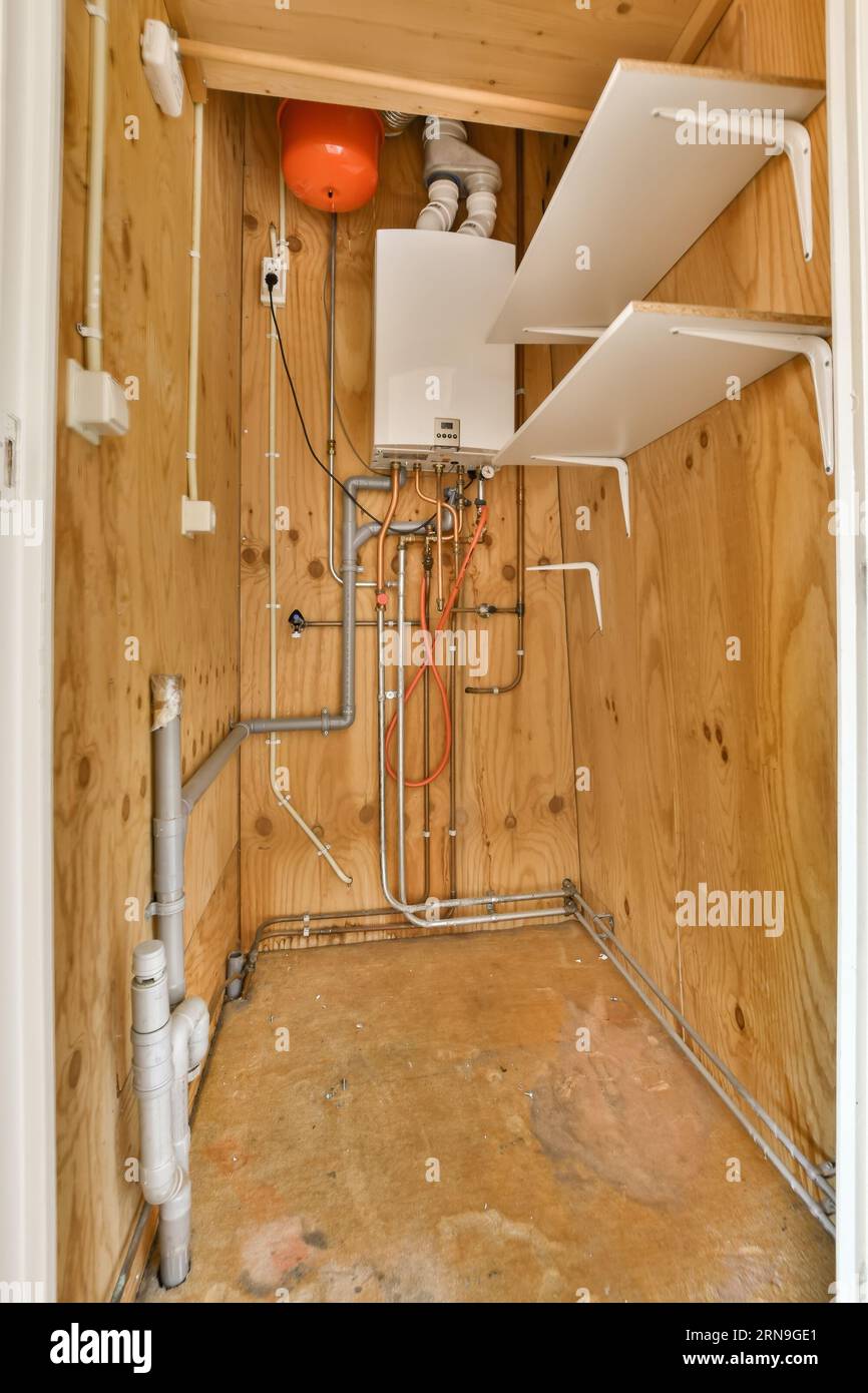 the inside of a room with pipes and water heater in it's corner, which ...