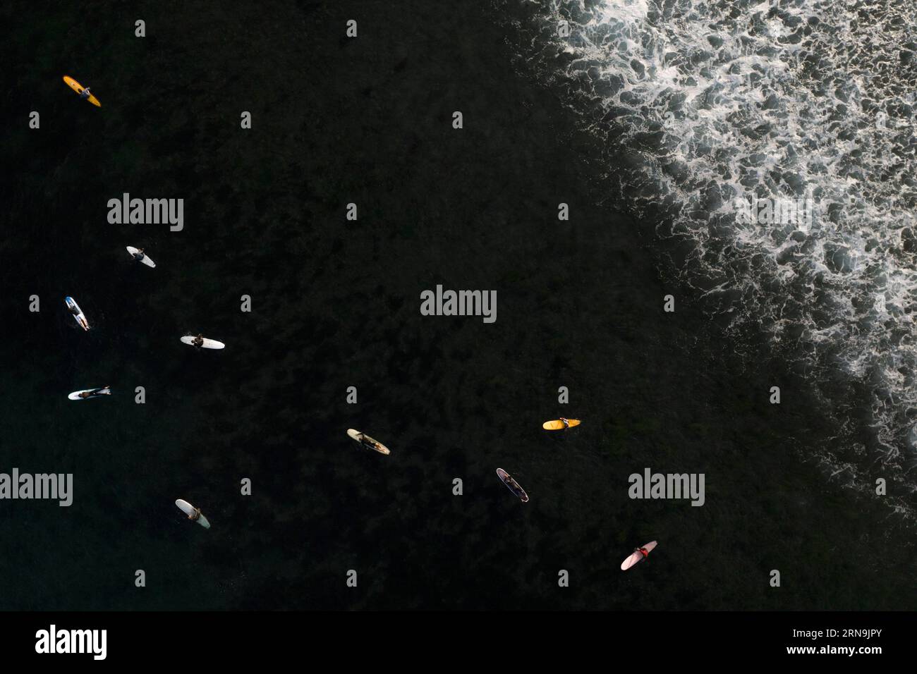 Surfers float in the water while waiting for a wave in Malibu, Calif ...