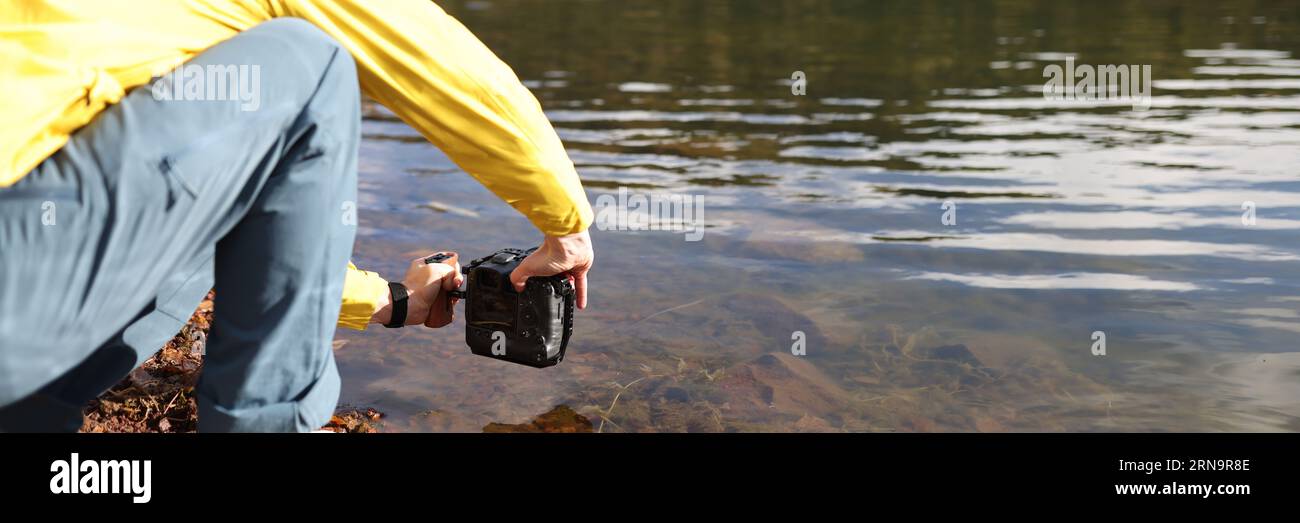 Man taking photo of lake using professional camera Stock Photo - Alamy