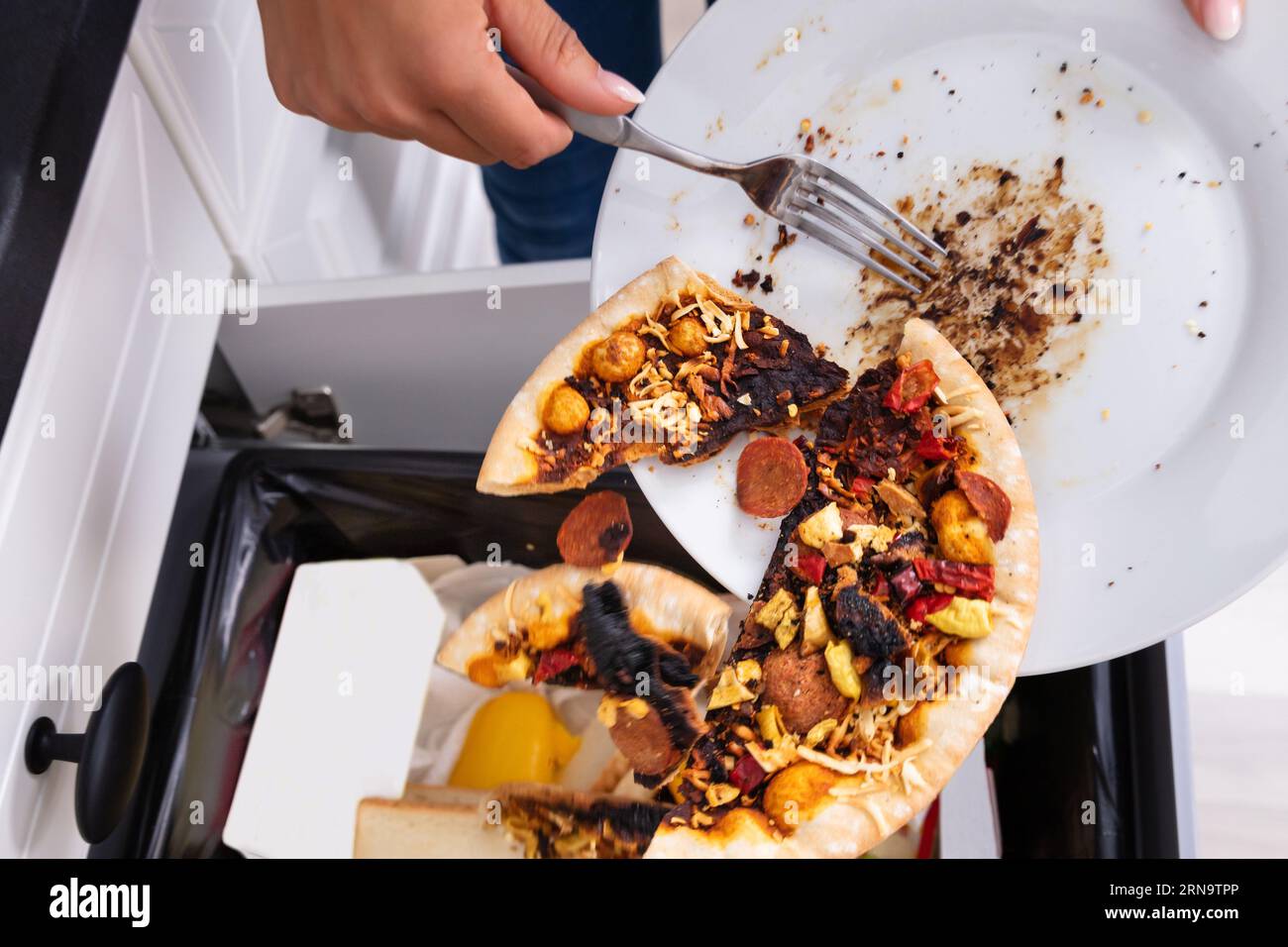 Close-up Of A Person Throwing Pepperoni Pizza On Plate In Dustbin Stock ...