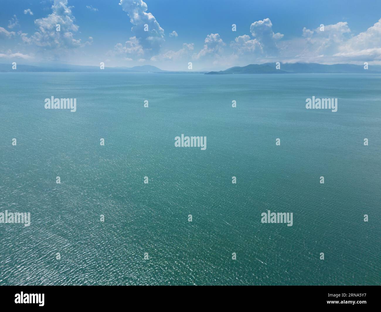 Aerial view of a blue sea water background and sun reflections. Aerial ...