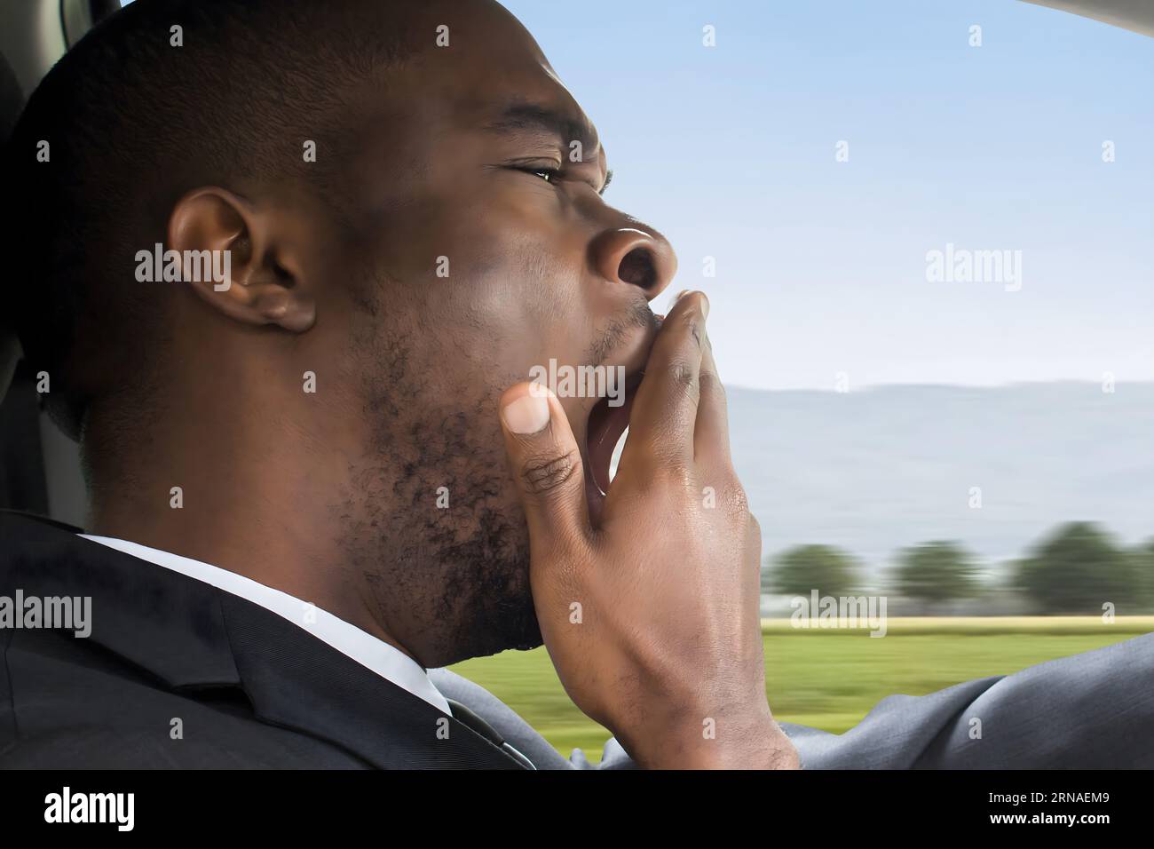Side View Of A Young African Businessman Yawning While Driving Car ...