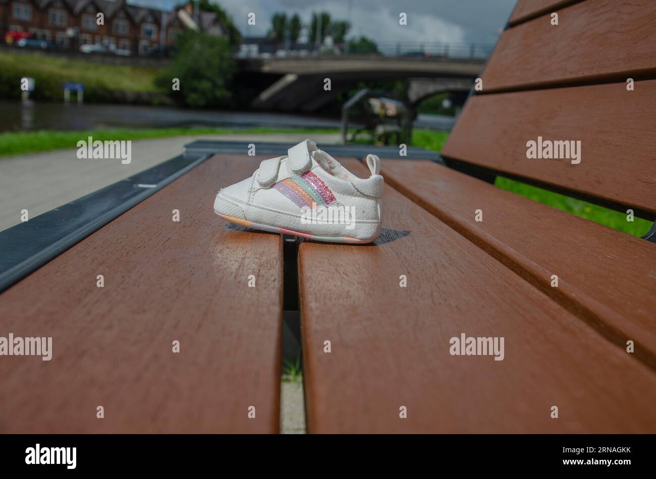 Child's lost shoe sitting on a park bench on the shores of Lough Erne ...