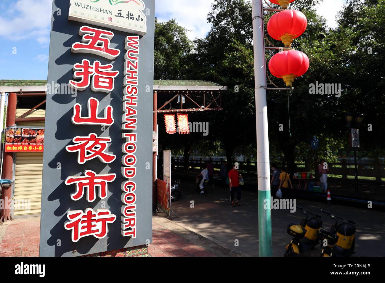 People select and buy products at the Hlai market in Wuzhishan City ...