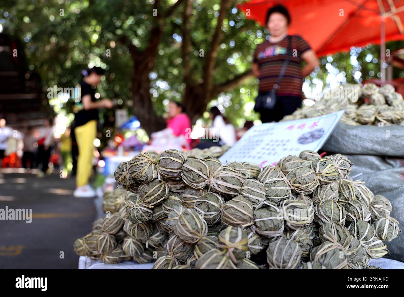 People select and buy products at the Hlai market in Wuzhishan City ...