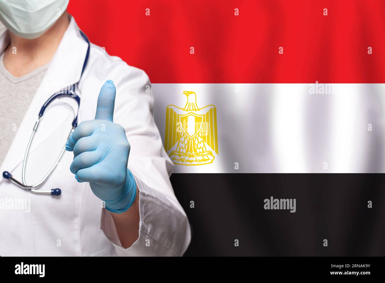 Egyptian doctor's hand showing thumb up positive gesture on flag of ...