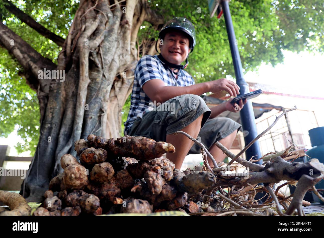 People select and buy products at the Hlai market in Wuzhishan City ...