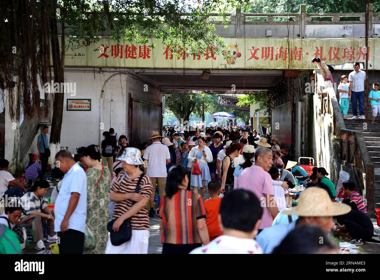 People select and buy products at the Hlai market in Wuzhishan City ...