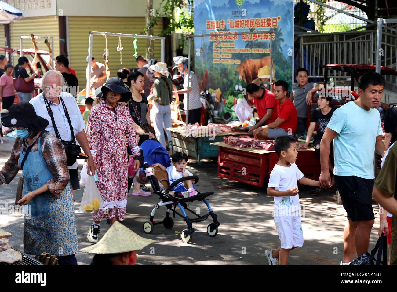 People select and buy products at the Hlai market in Wuzhishan City ...