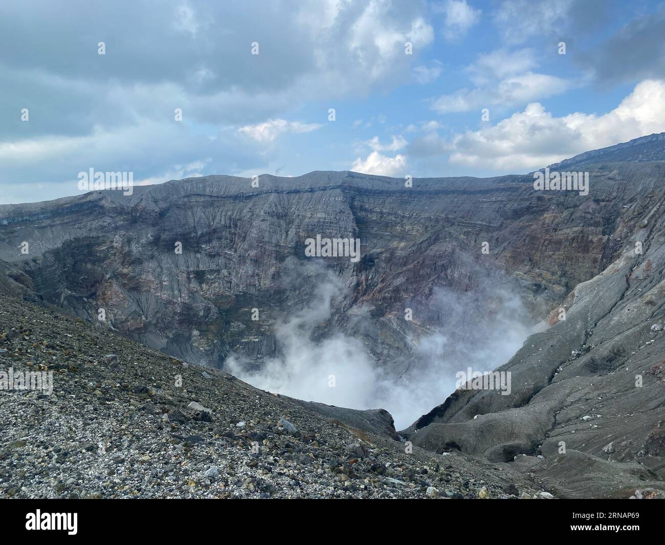 A scenic view of a barren landscape with a smoke emerging from a ...