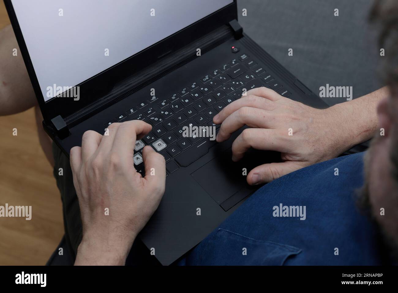 anonymous man using a laptop on the sofa Stock Photo - Alamy