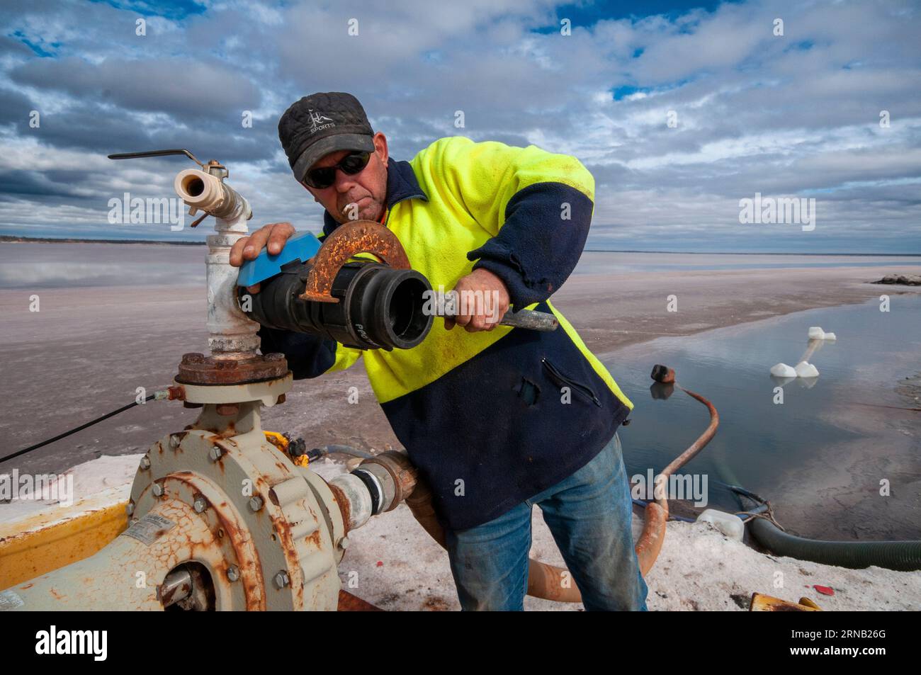 Salt miners pumping water between evaporative ponds for salt mining at ...