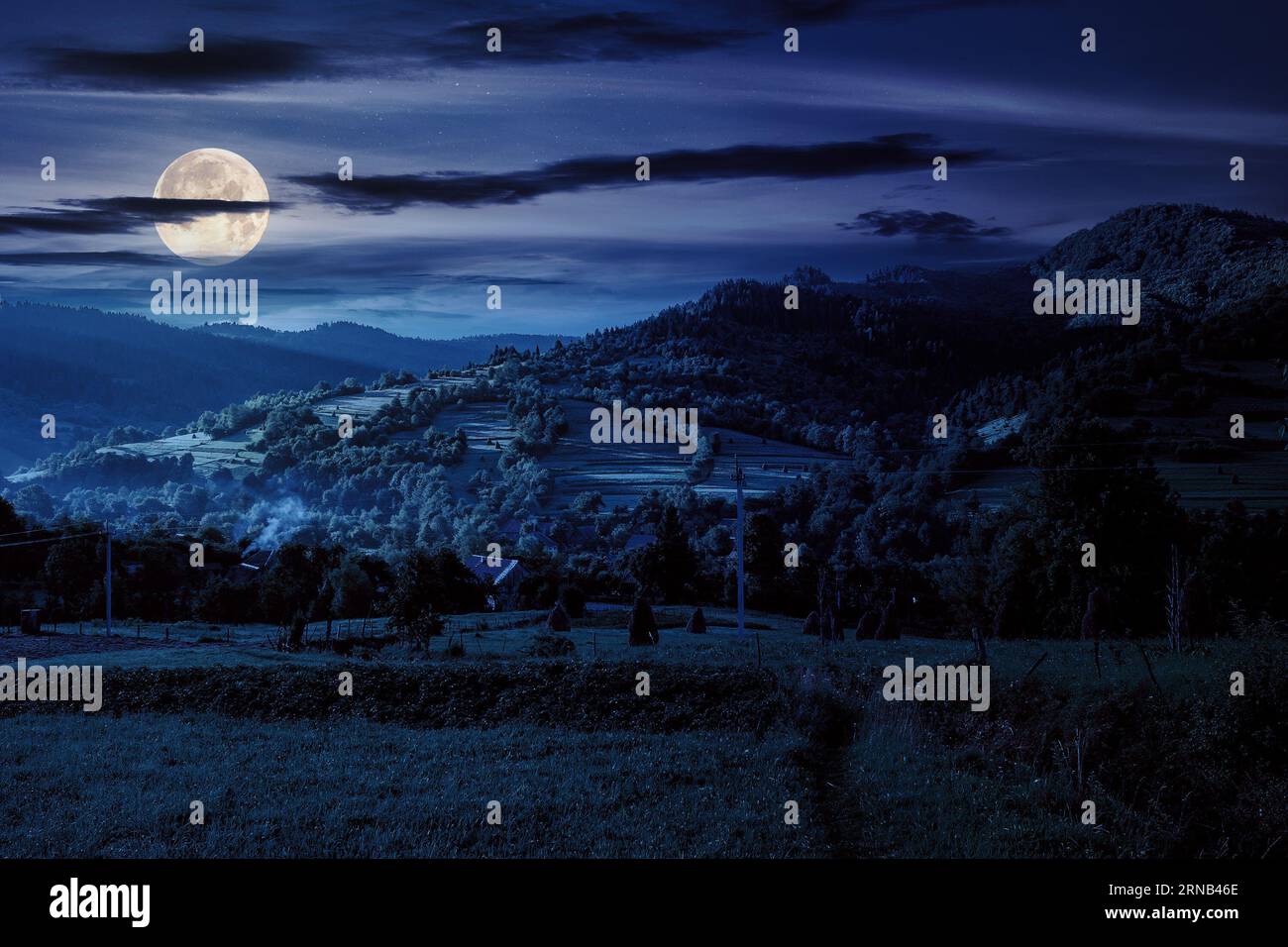 rural landscape in summer at night. village in the valley with ...