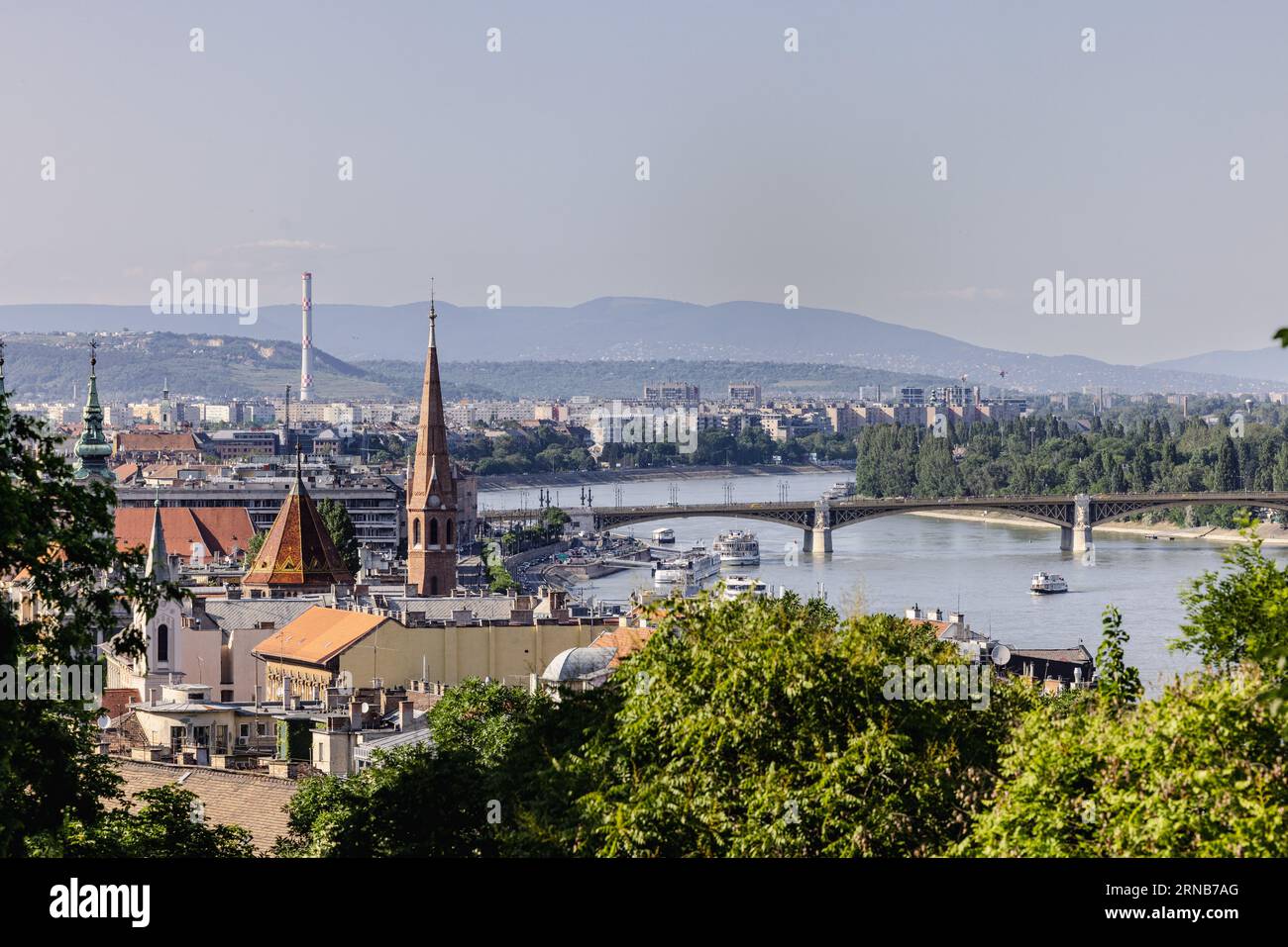 An aerial view of Budapest, Hungary, with the lush green trees and blue ...