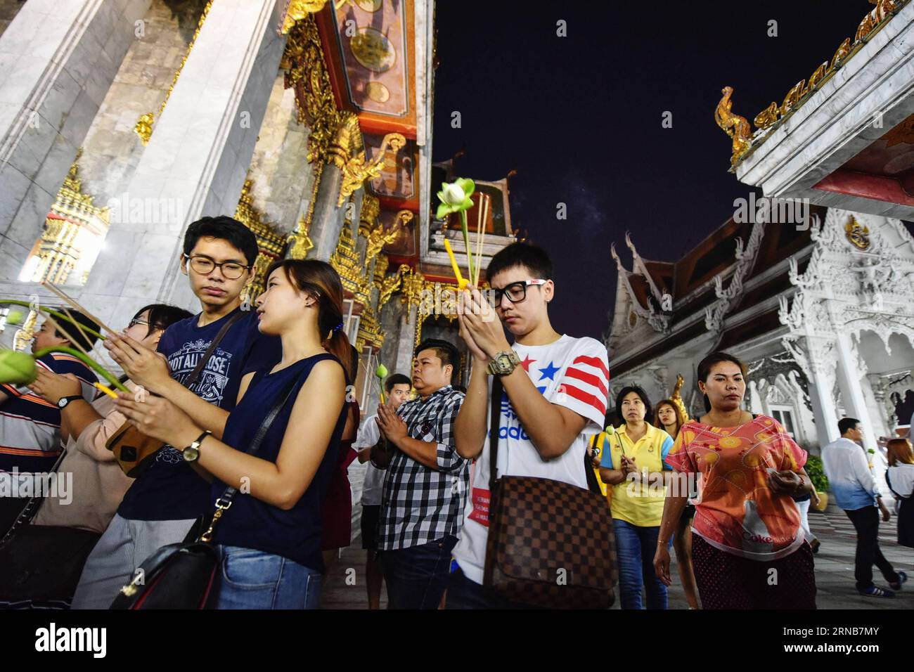 People join in a Makha Bucha candle-light procession around the main ...