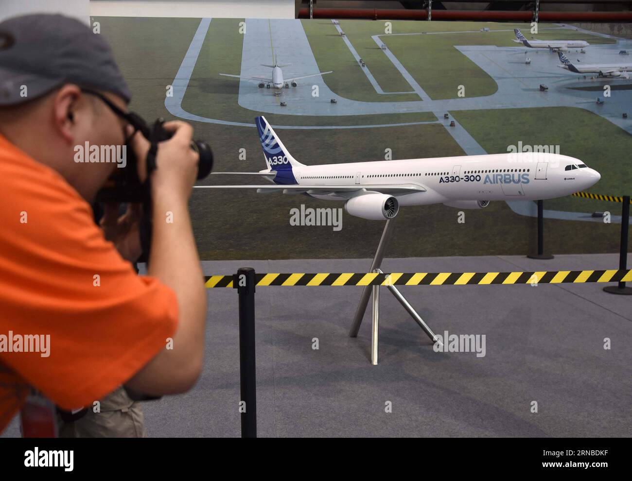 A man takes pictures of an A330 aircraft model at the ground breaking ...