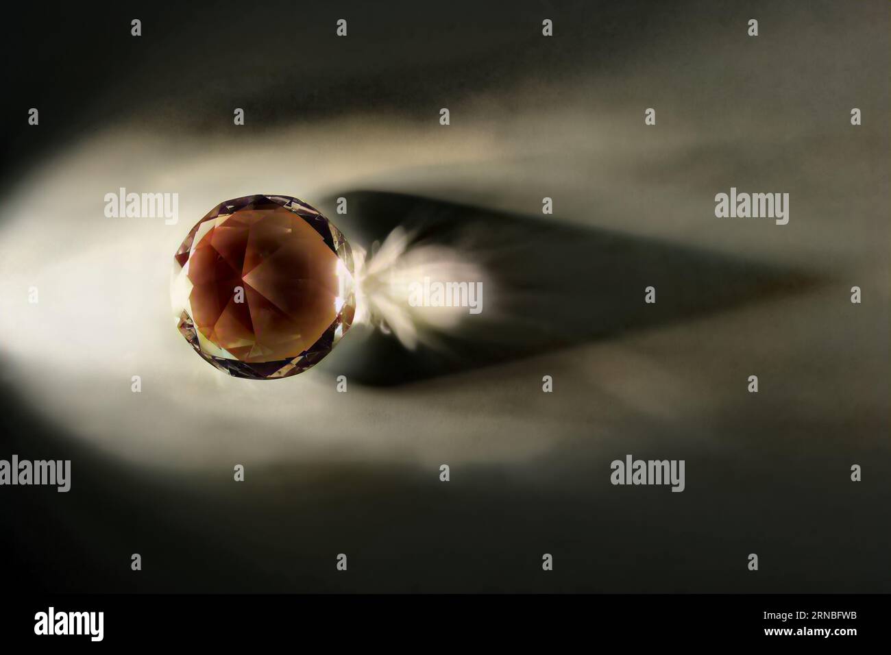 real glass object with shadows formed as diamond on white table with ...