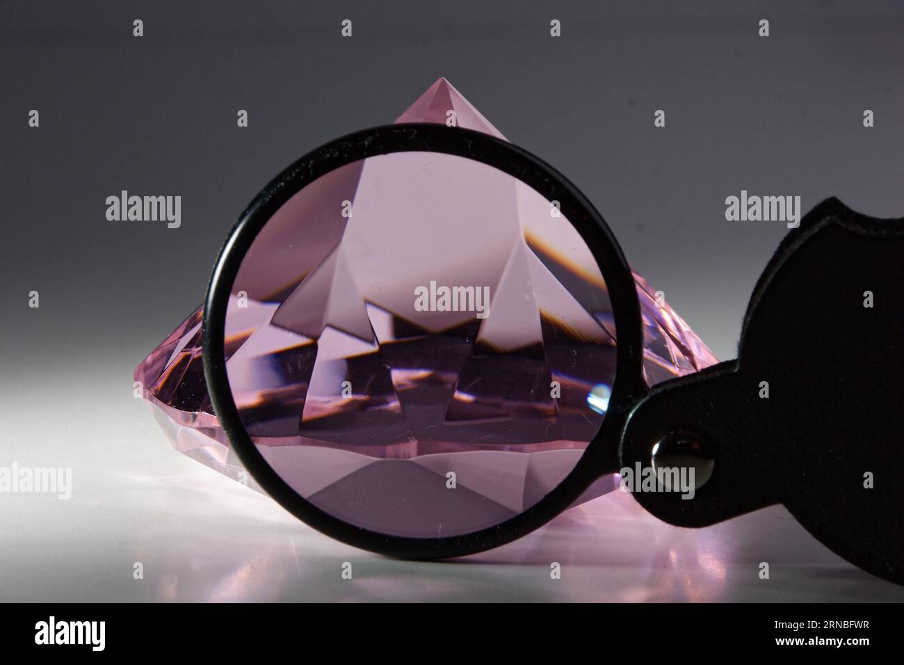 real glass object with shadows formed as diamond on white table with ...