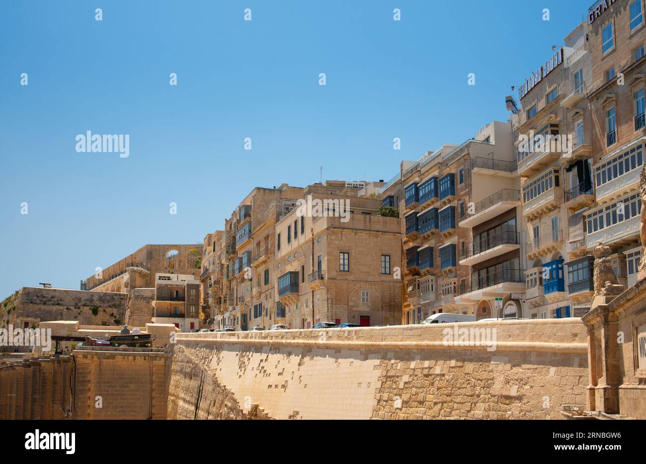 Detail shot of the coast of Malta with historic houses behind the thick ...