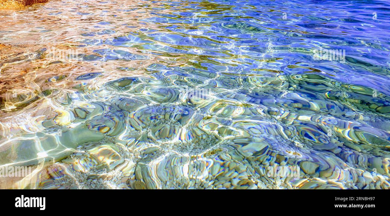 Summer sun reflects on the clear ocean water in multiple colours Stock ...